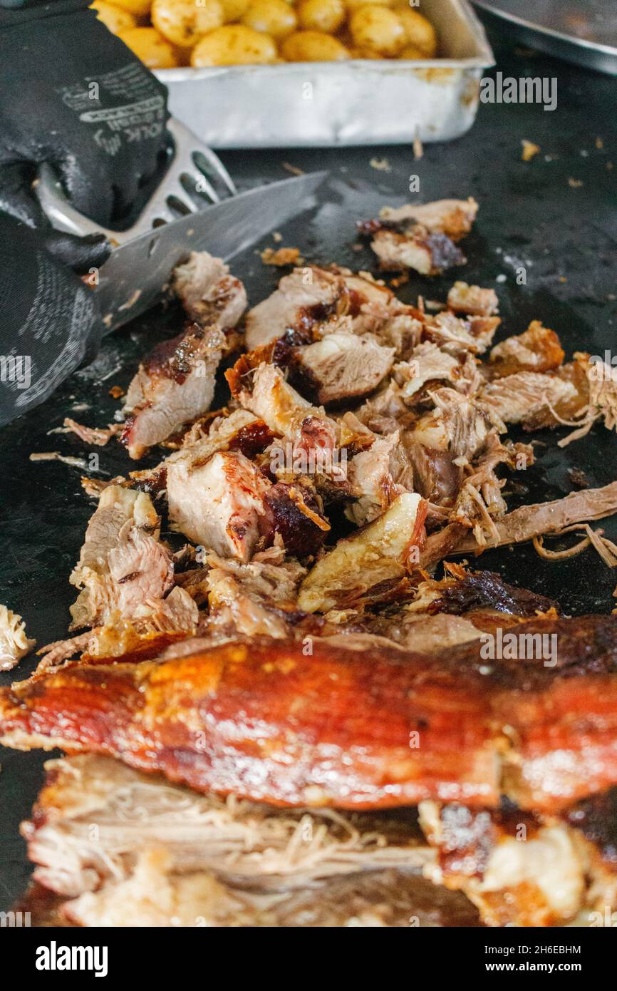 grilled pieces of pork meat getting cut off by a hand Stock Photo - Alamy
