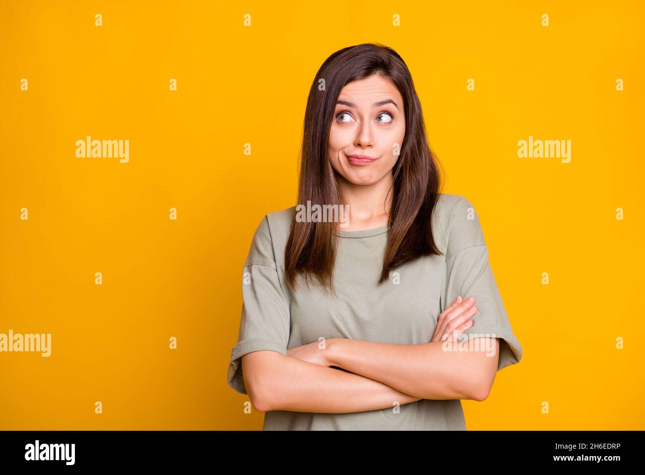 Portrait of lovely confused brown-haired girl folded arms thinking copy ...