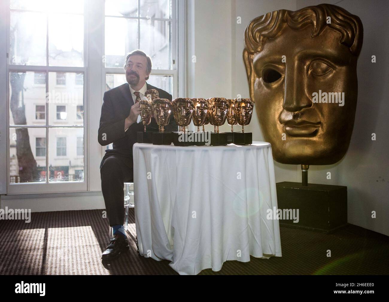 BAFTA Film host host Stephen Fry buffs and polishes the masks ahead of ...