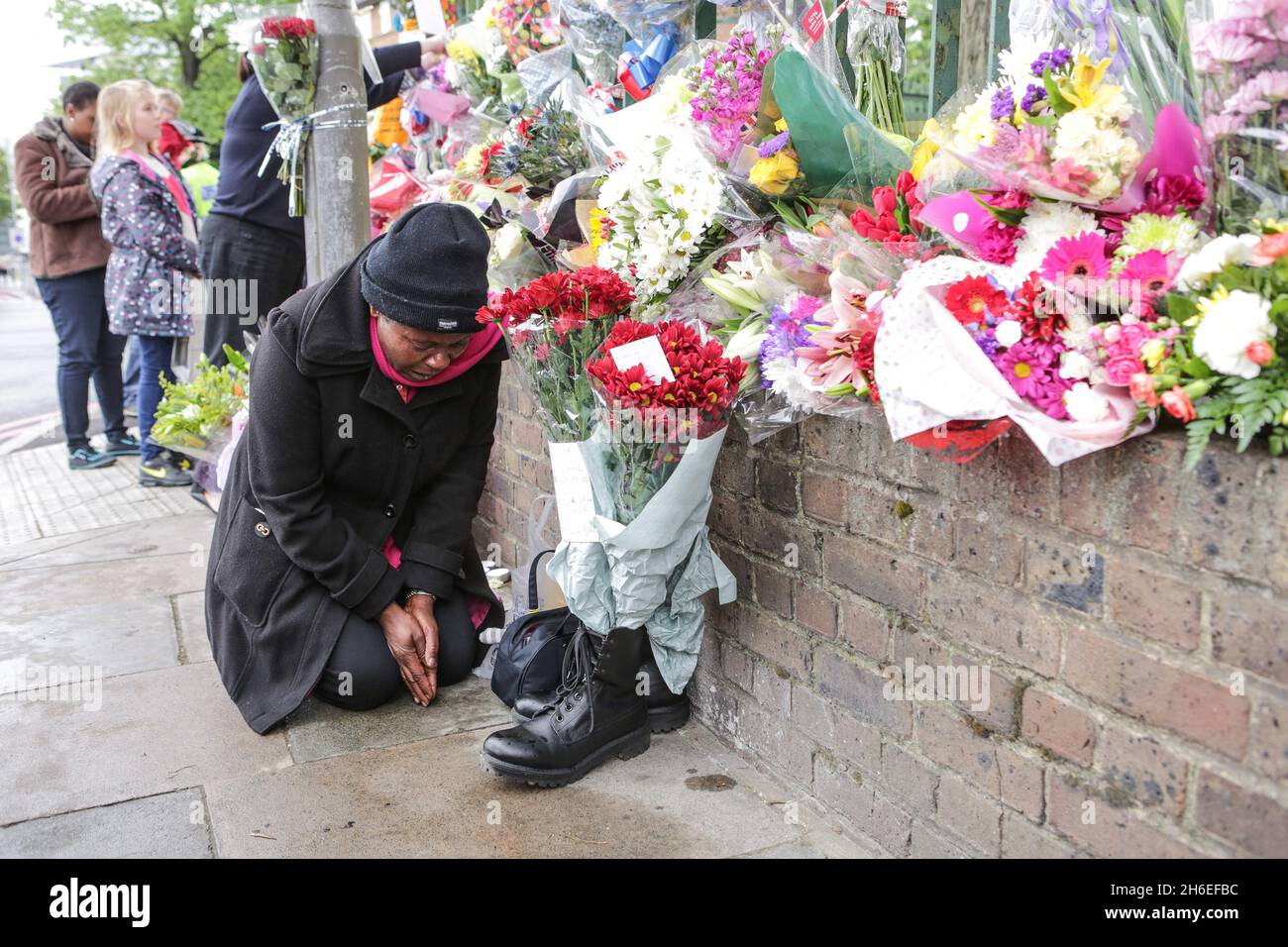 The mother of a friend of Lee Rigby lays flowers at the scene where the ...