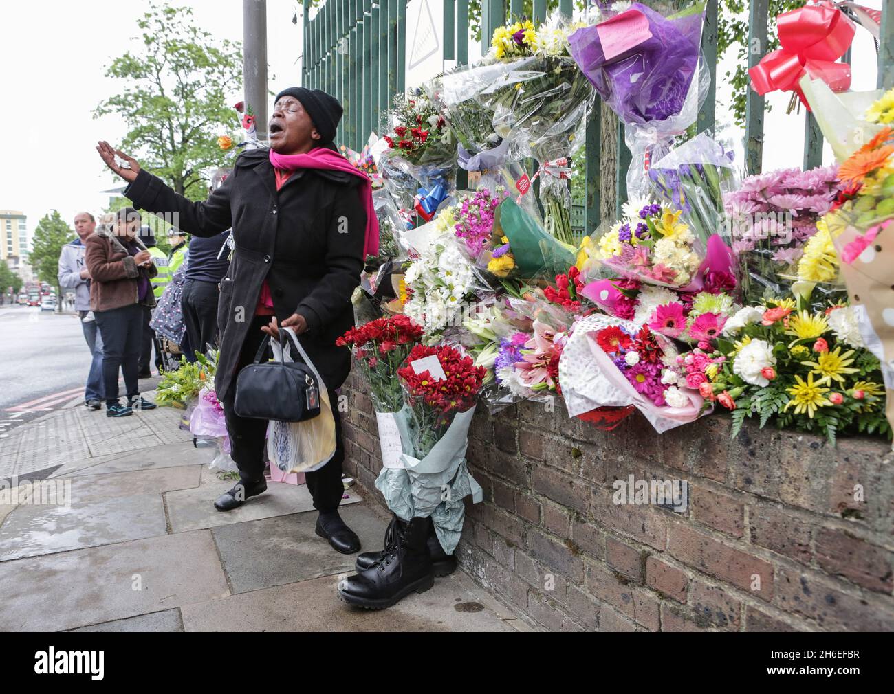 The mother of a friend of Lee Rigby lays flowers at the scene where the ...