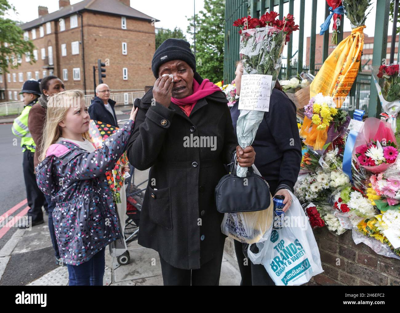 The mother of a friend of Lee Rigby lays flowers at the scene where the ...
