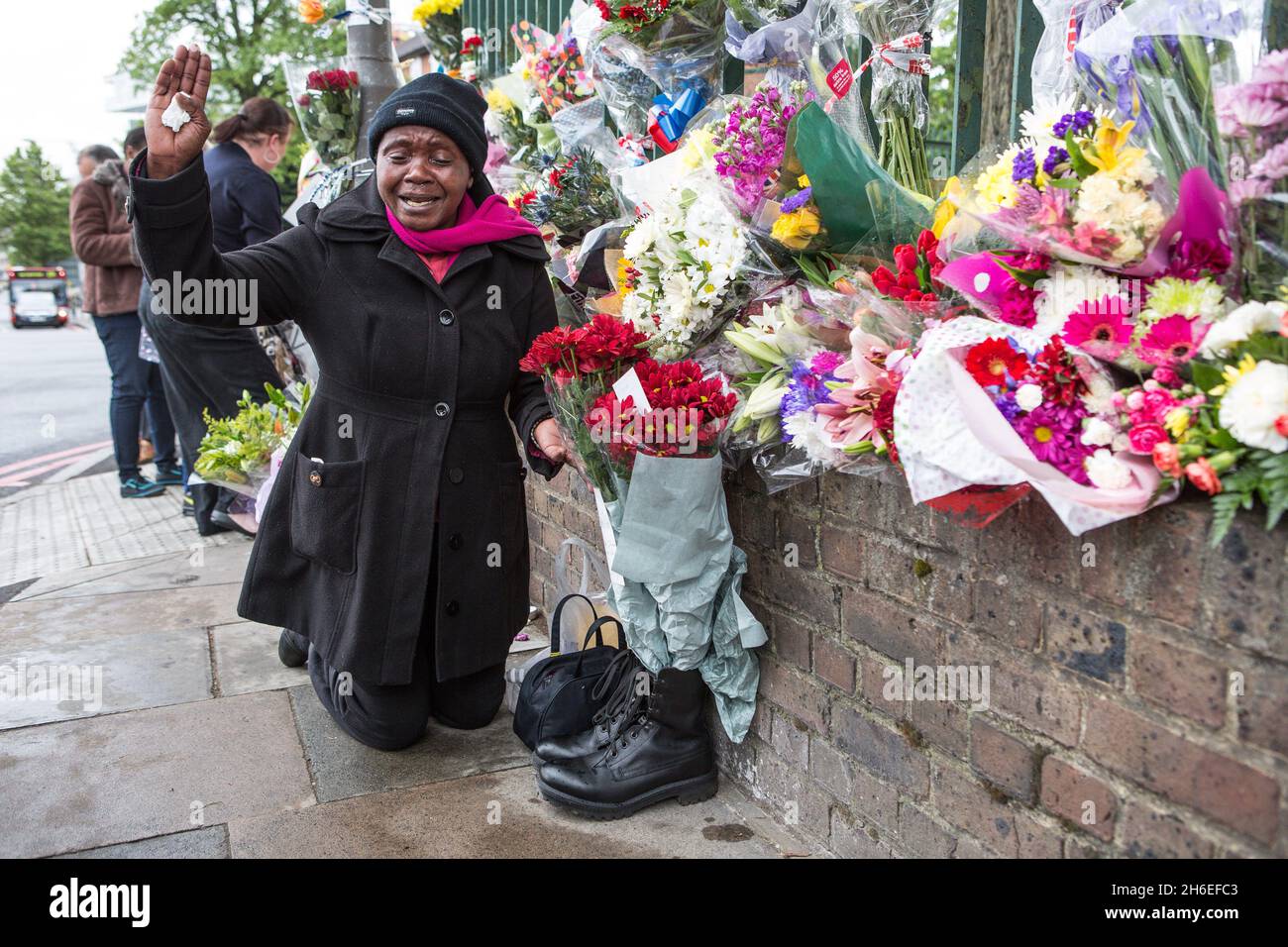 The mother of a friend of Lee Rigby lays flowers at the scene where the ...