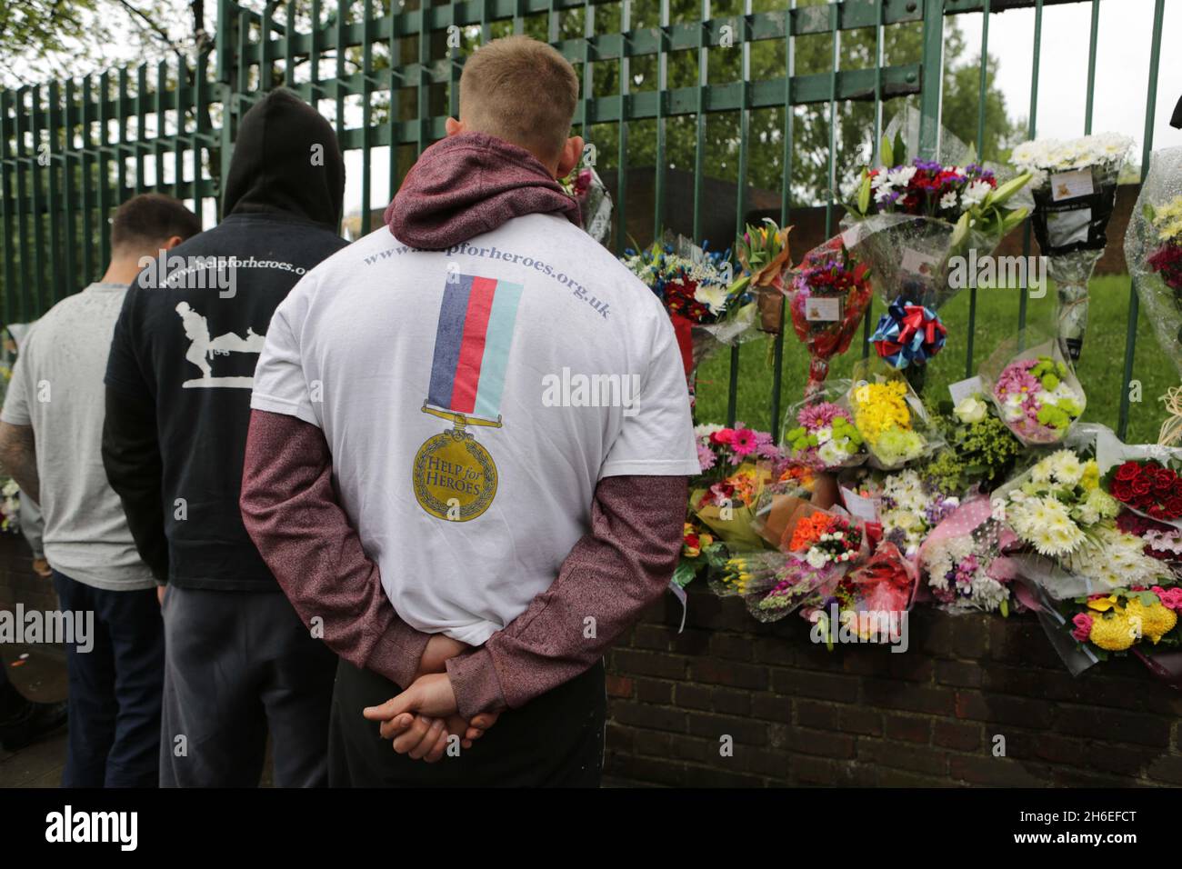 Men wearing Help For Heroes clothing leave flowers at the scene where ...