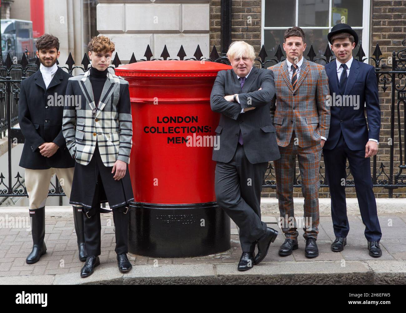 Boris Johnson attending a photocall on Savile Row, alongside nine male ...