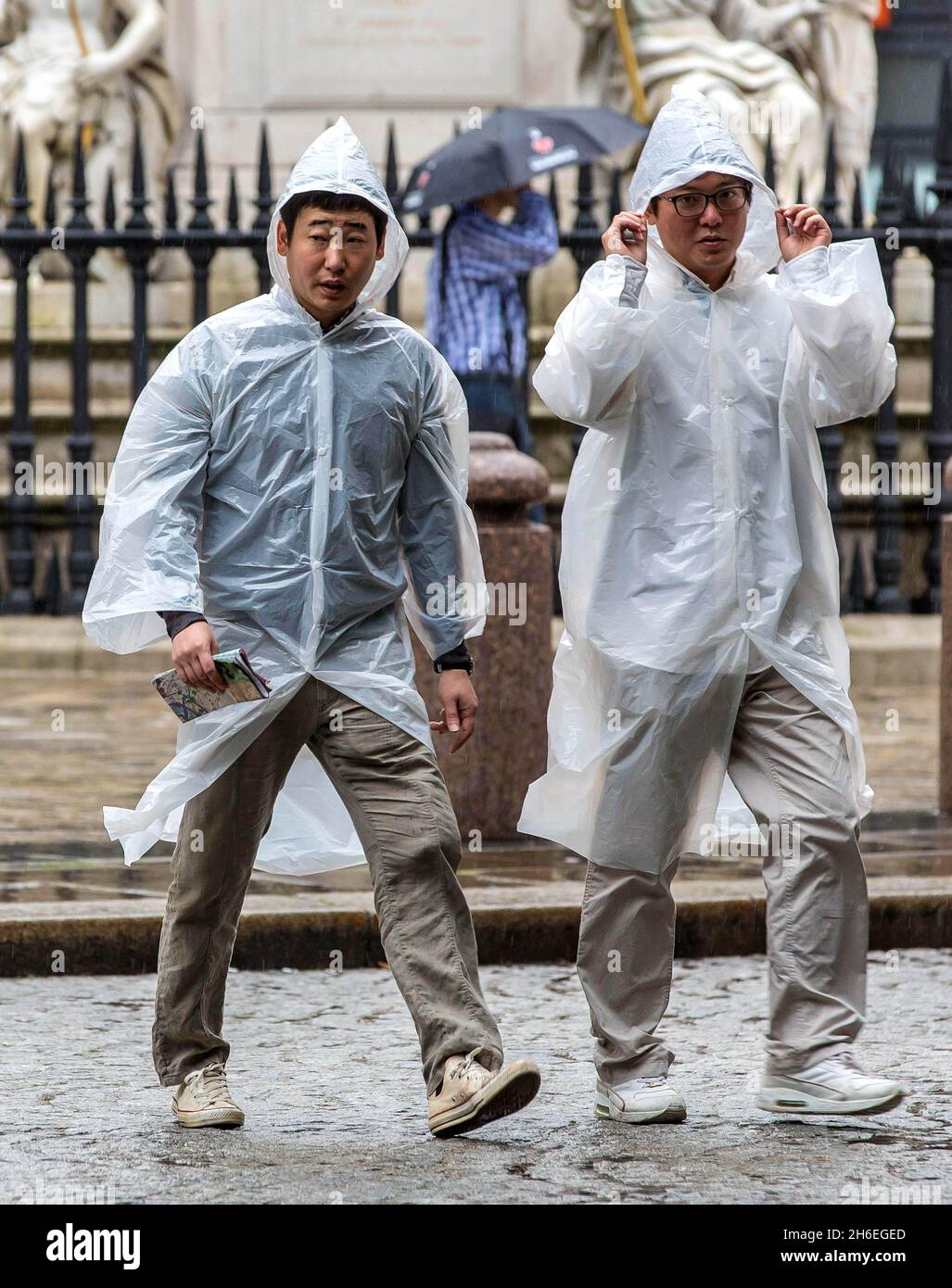 Office workers and tourists are pictured in the rain outside St Paul's ...