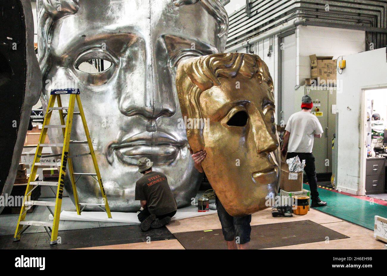 Stage crew at t the Royal Opera House work on the giant BAFTA masks ...