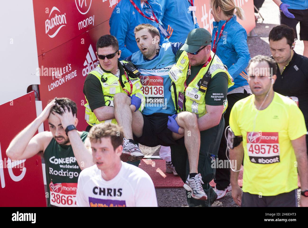 A runner is helped at the finish line at the London Marathon Stock ...