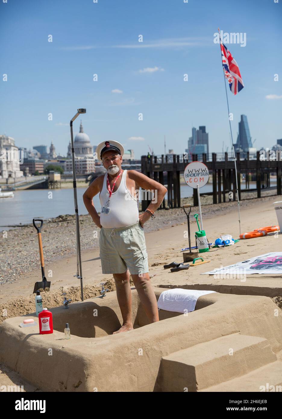 A sculptor creates a sand shower to cool down in central London this ...