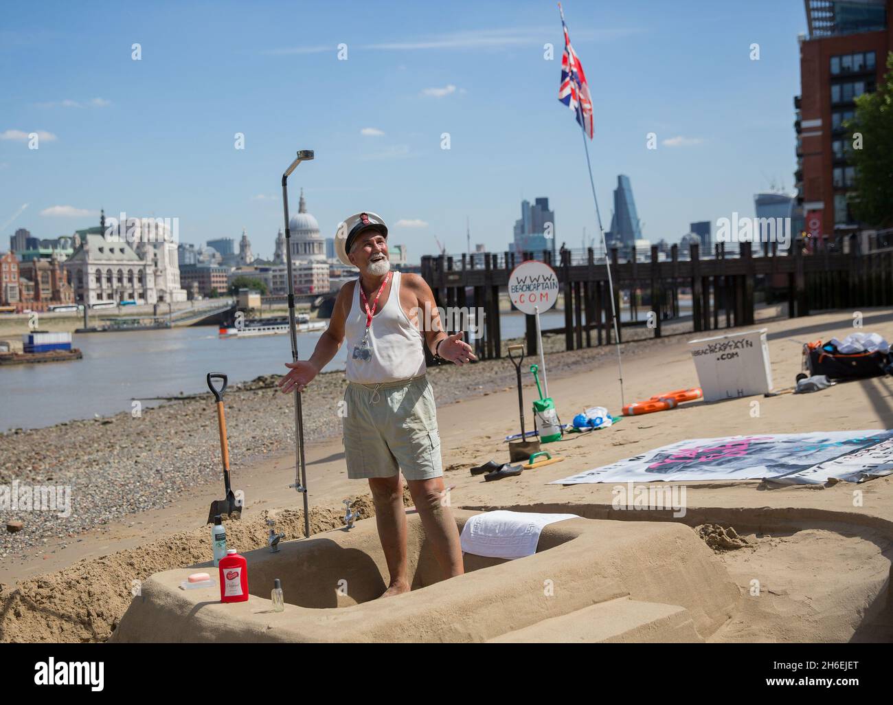 A sculptor creates a sand shower to cool down in central London this ...