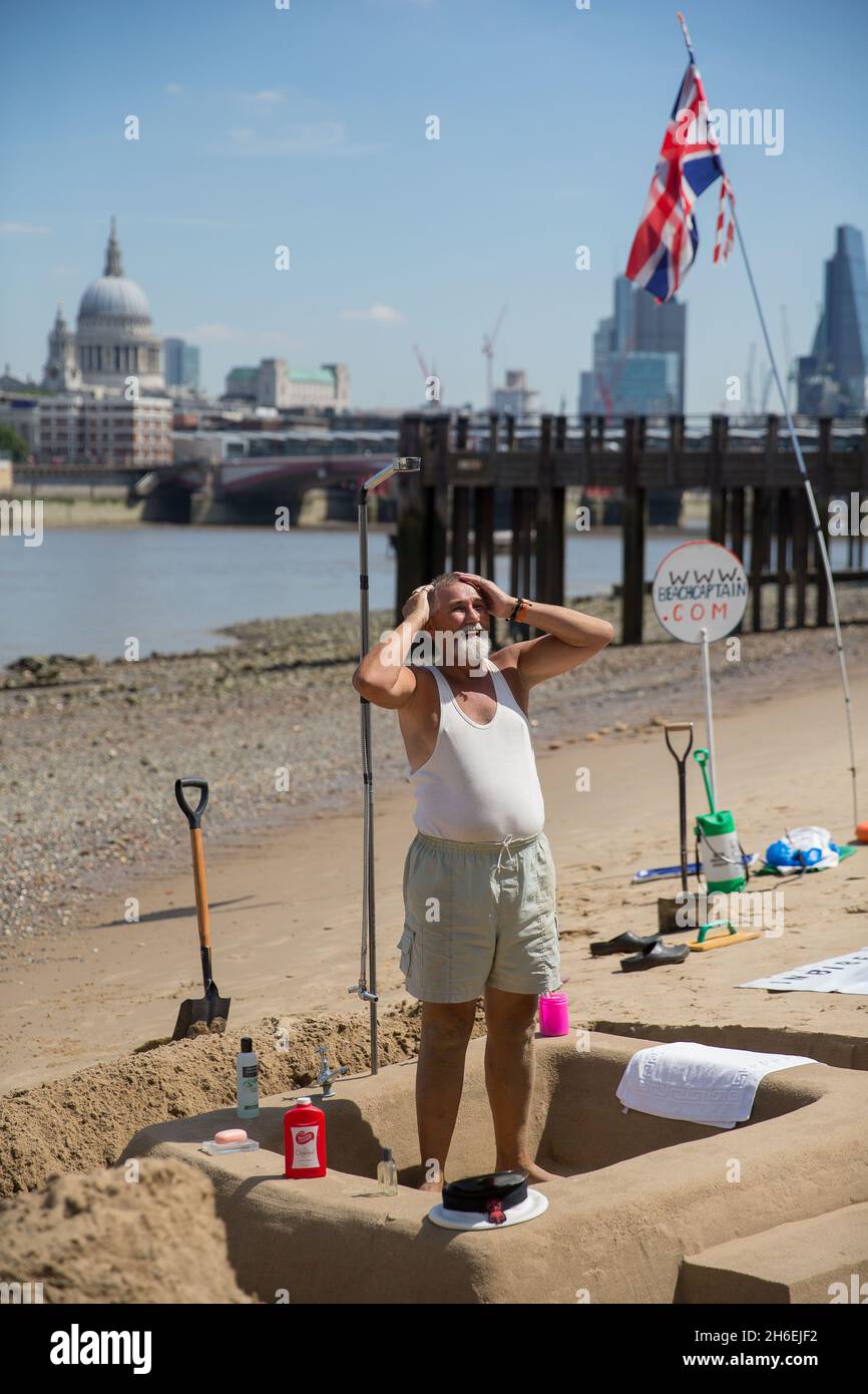 A sculptor creates a sand shower to cool down in central London this ...