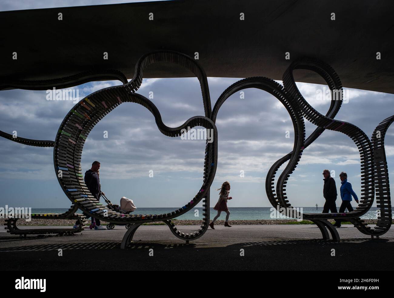 Members of the public walk past the The Long Bench at Littlehampton.The ...