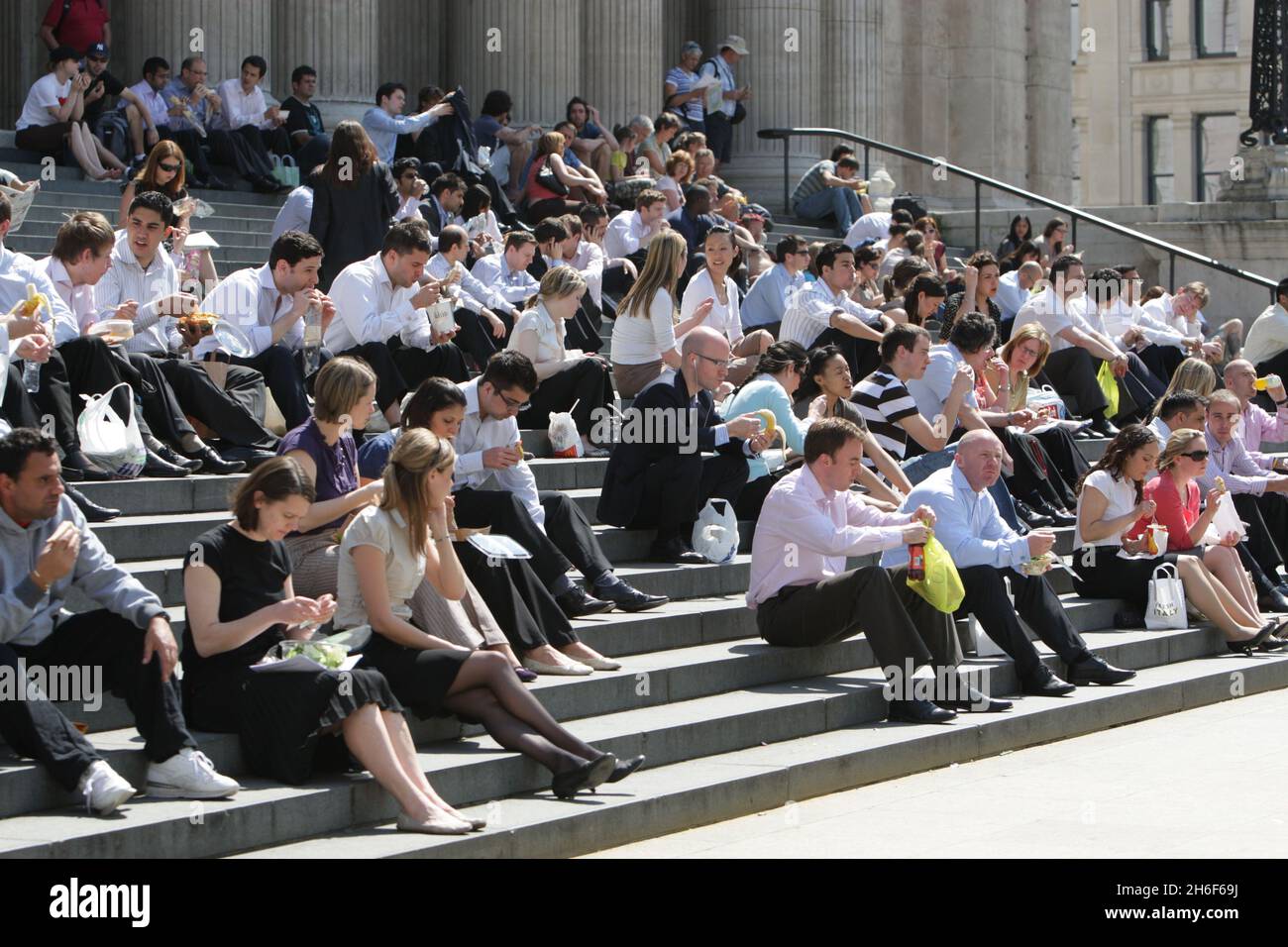 City workers enjoy their lunch on the steps of St Paul's Cathedral ...
