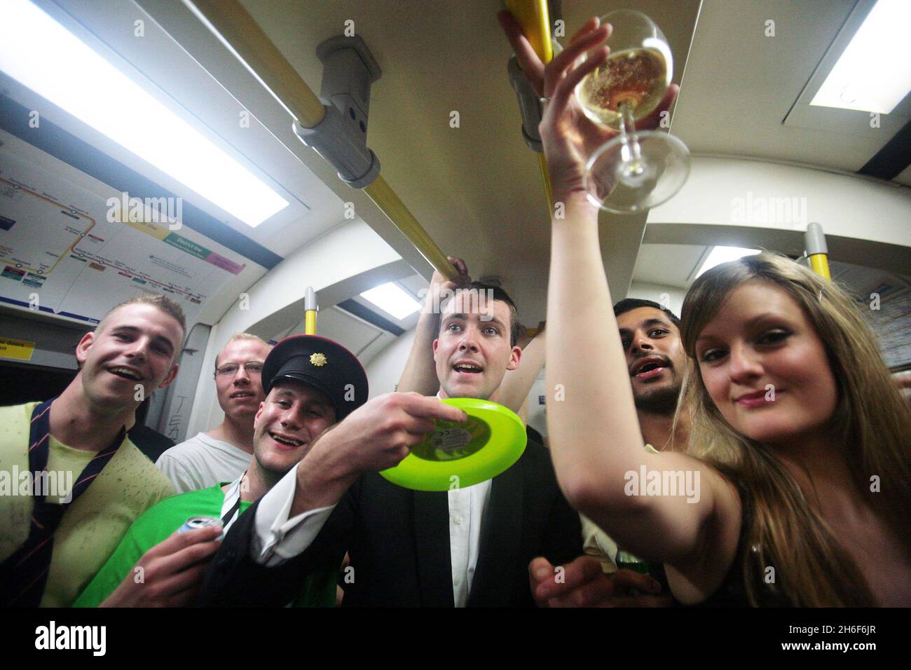 Revellers drink on a tube train, before the ban on drinking alcohol ...