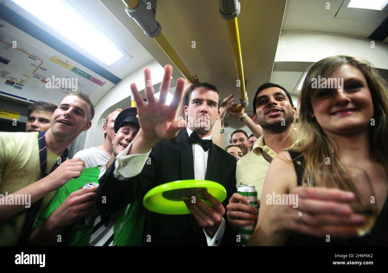 Revellers drink on a tube train, before the ban on drinking alcohol ...