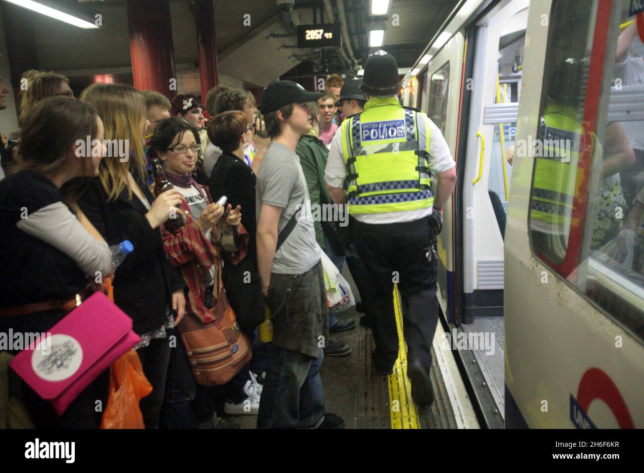 Revellers drink at a tube station, before the ban on drinking alcohol ...