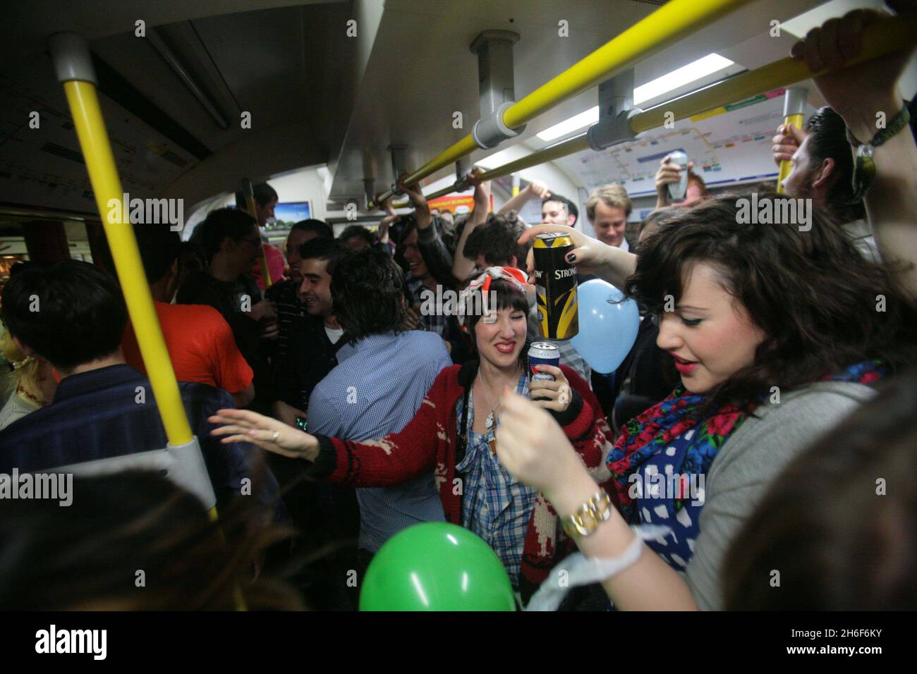 Revellers drink on a tube train, before the ban on drinking alcohol ...