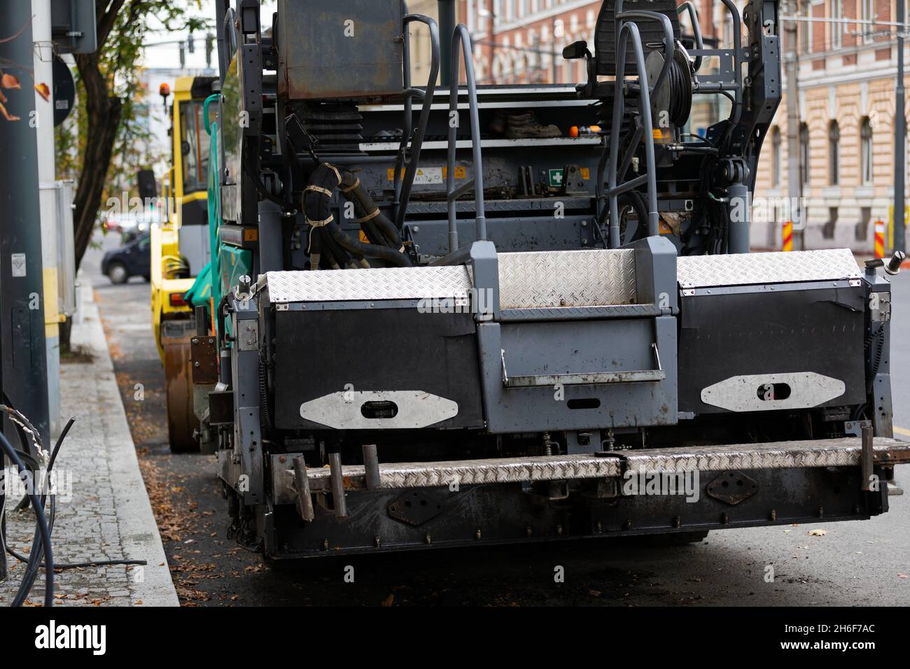 Industrial pavement machine laying fresh asphalt on street Stock Photo ...