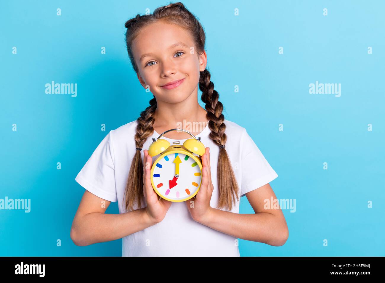 Photo of young small girl happy positive smile hold clock alarm timer ...