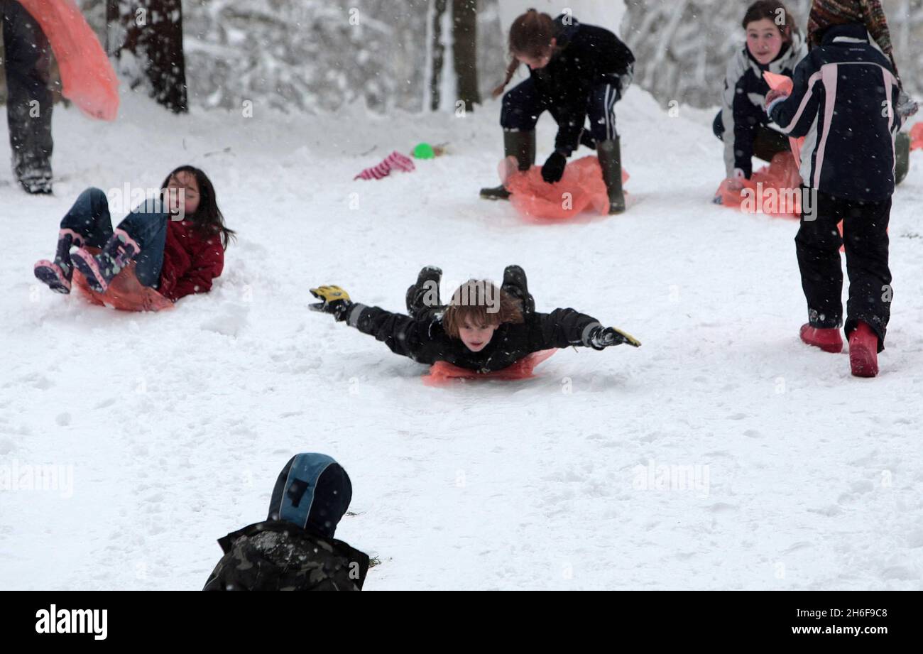 Children sledge on plastic bags in St James Park, London after heavy ...