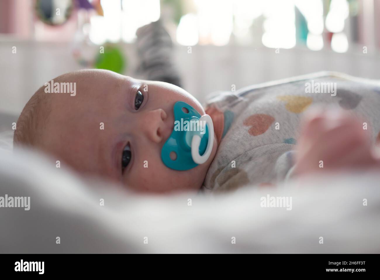 Cute little baby with pacifier resting in bed Stock Photo - Alamy