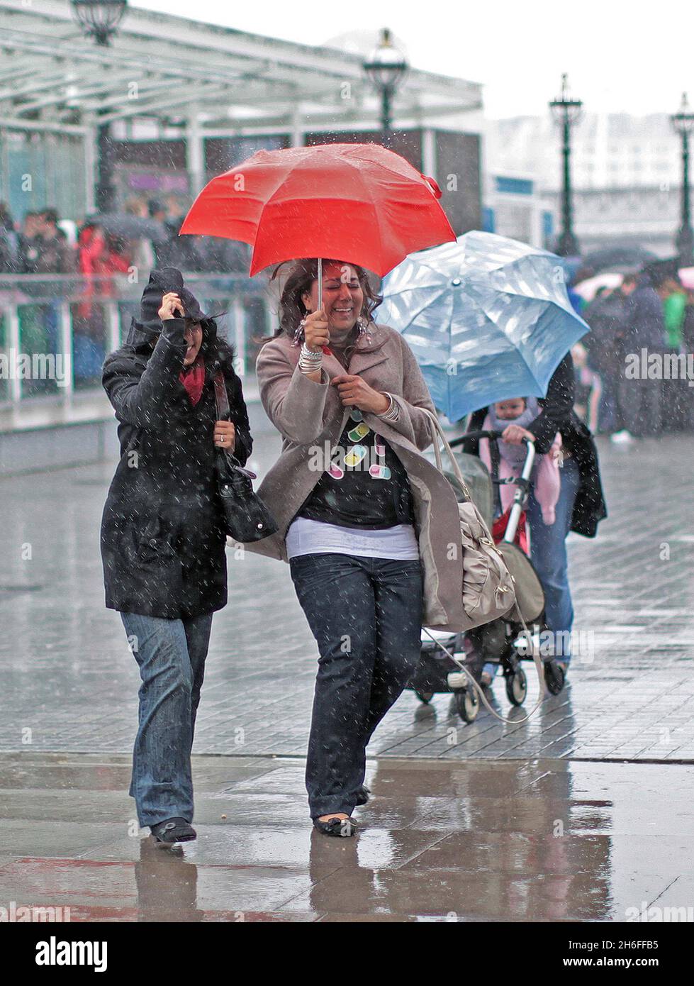 Heavy rain hit London this afternoon. Picture shows: Tourists caught in ...