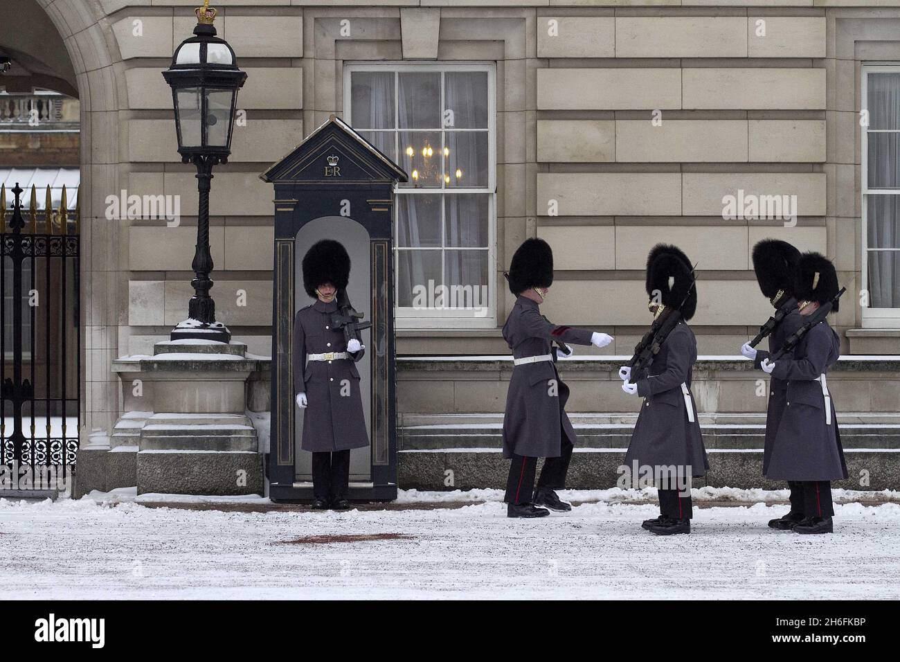 Guards pictured outside Buckingham Palace in the snow in central London ...