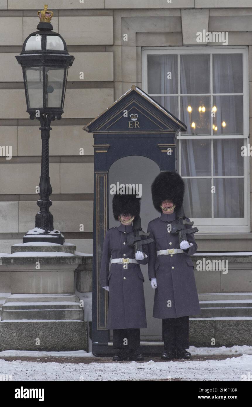 Guards pictured outside Buckingham Palace in the snow in central London ...
