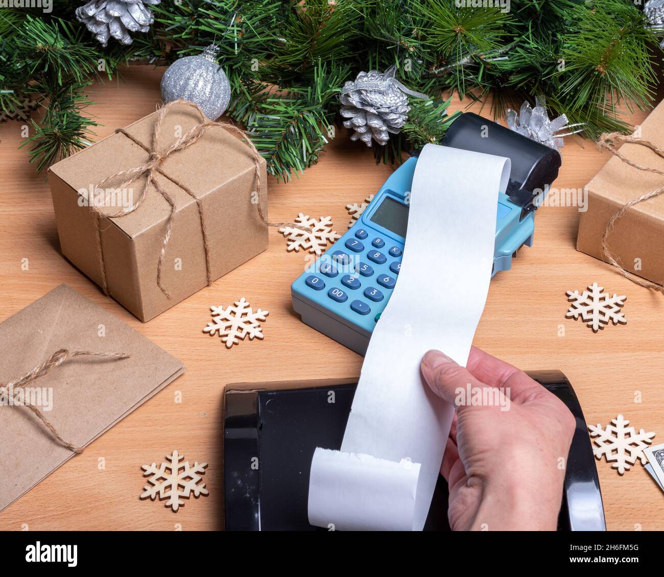 Hand holding a blank long cash register receipt from the cash register ...