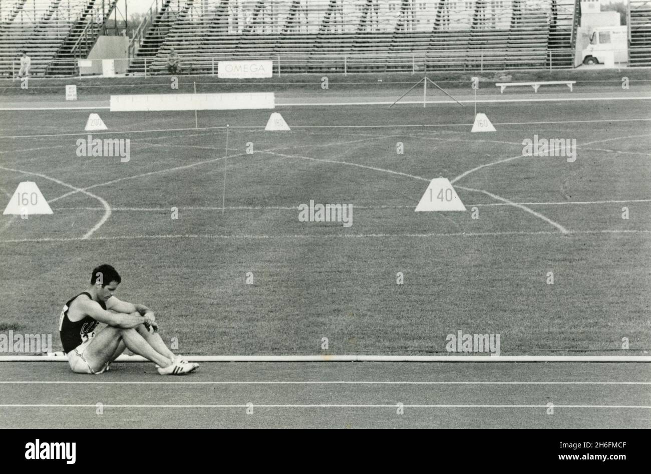 American track and field athlete Bill Toomey sitting on the field track ...