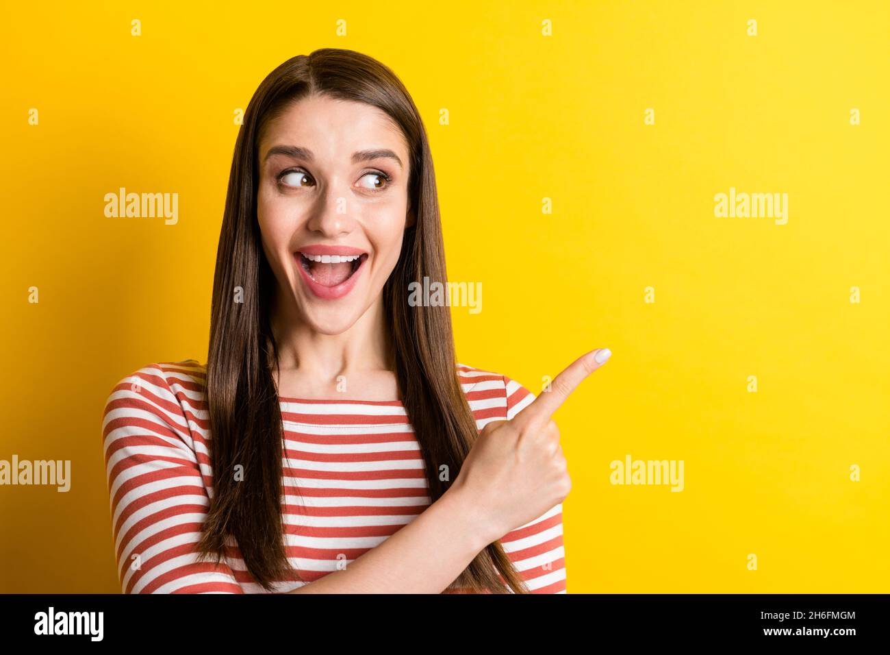 Portrait of attractive amazed cheerful girl demonstrating copy space ...