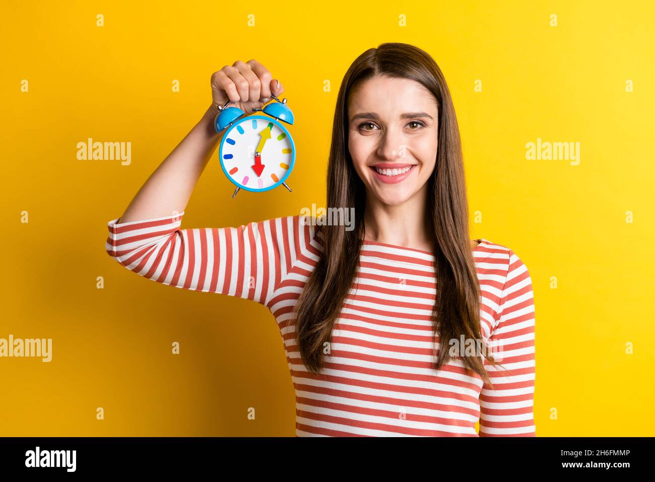 Portrait of attractive cheerful girl holding clock early wake up call ...