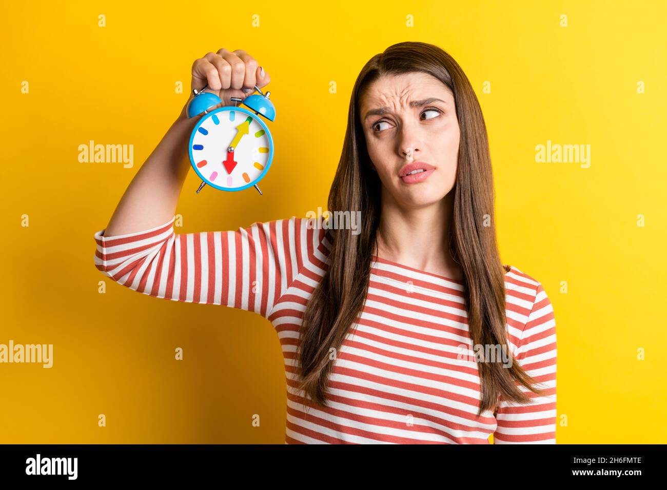 Portrait of attractive tired overwhelmed girl holding clock early hour ...