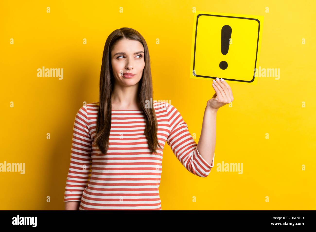 Portrait of attractive doubtful girl holding exclamation point card ...