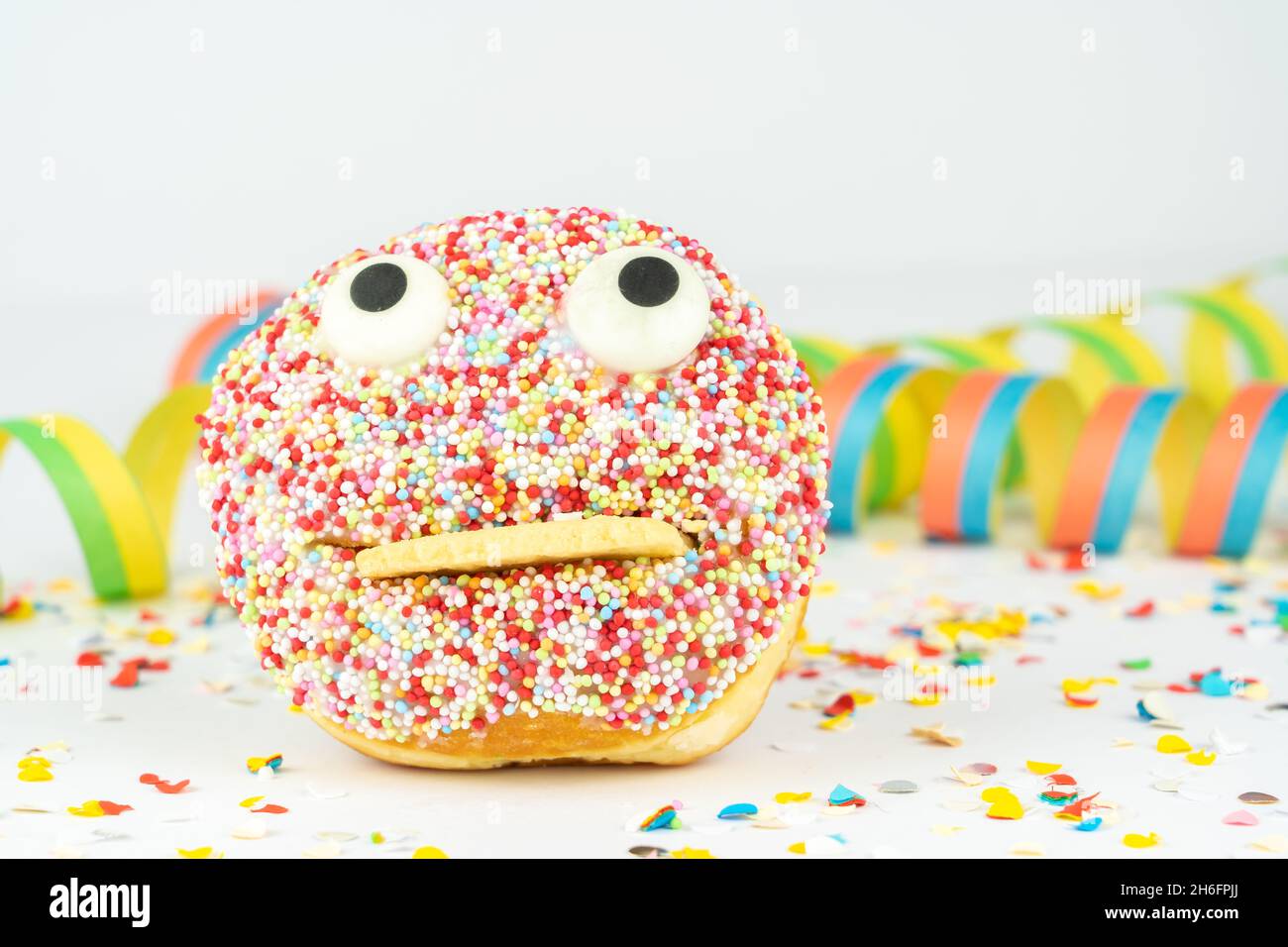 Funny face cake with confetti and streamers on white background Stock ...