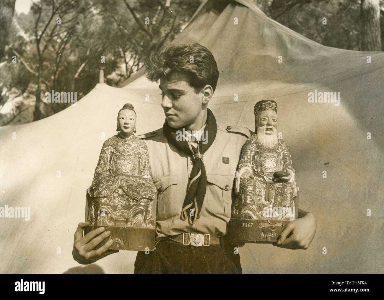 Boy Scout showing Asian statues, Italy 1950s Stock Photo - Alamy