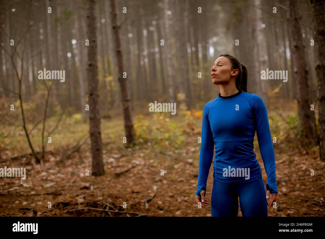 Pretty young woman take a break during outdoor exercise on the forest ...