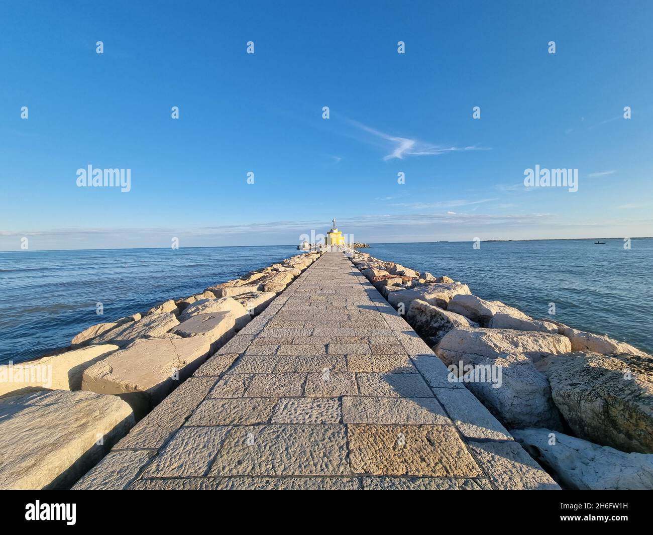 Beautiful shot of a pathway surrounded by a sea under the clear skies ...