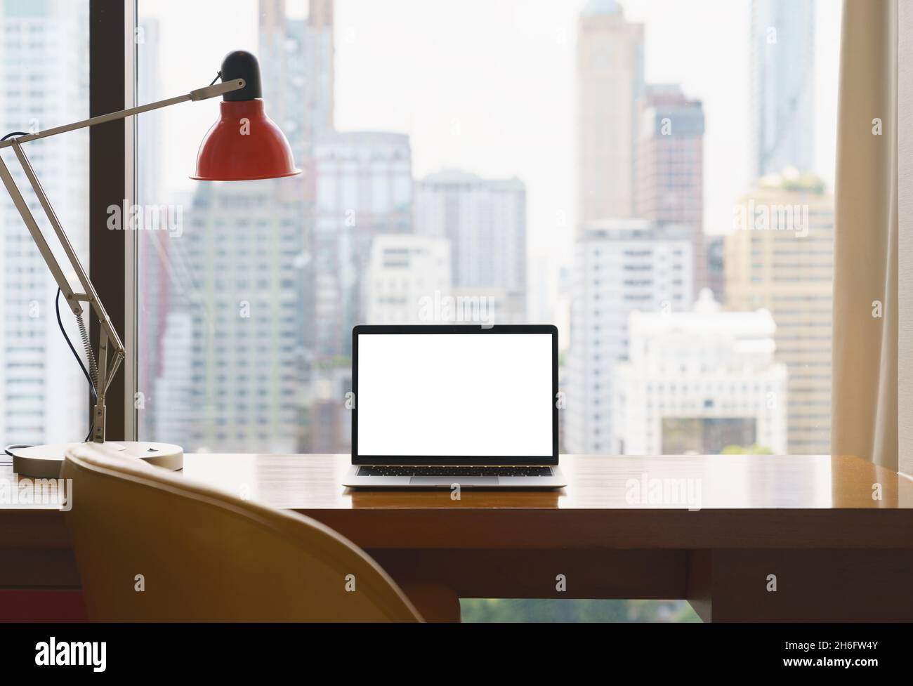 laptop white screen display on workspace see through city blur ...