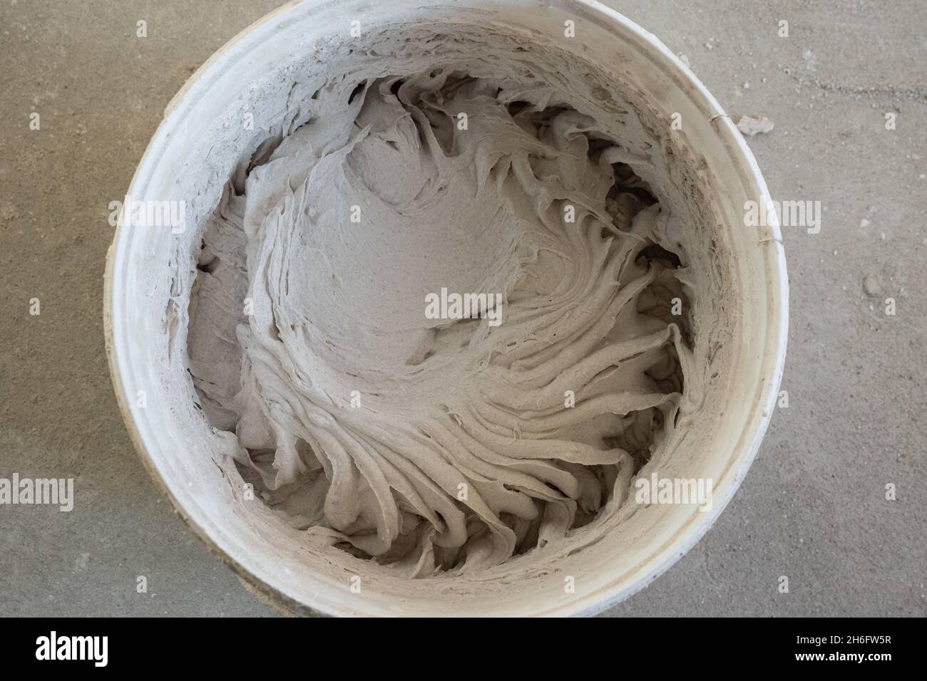 View from above, mixed in a white plastic bucket plaster. Dry mix mixed ...