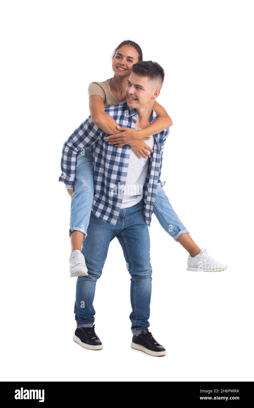 Young male carrying his girlfriend piggyback isolated on white ...