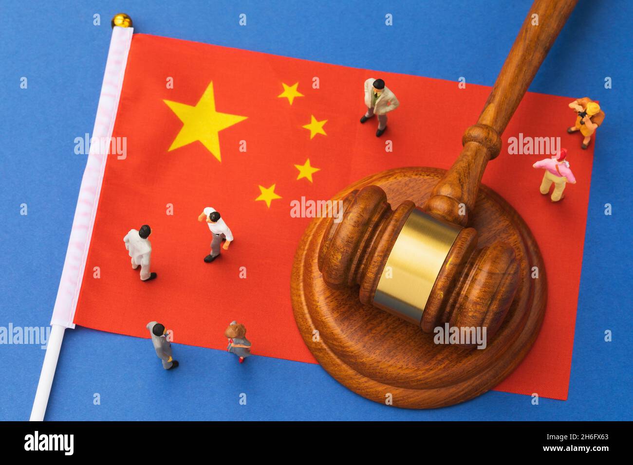 Judicial hammer, flag of China and plastic toy men on blue background ...
