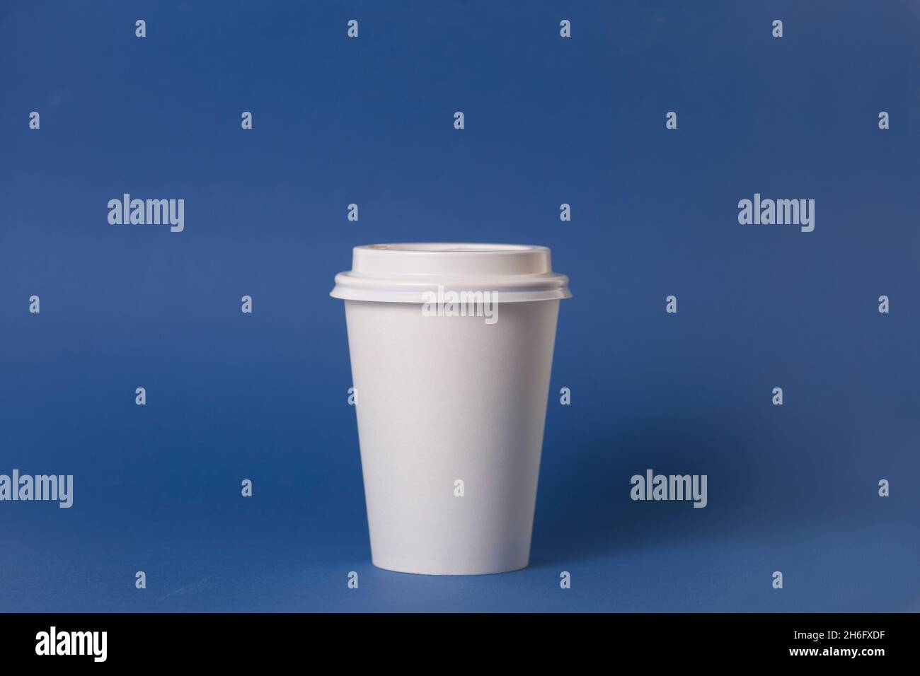 white coffee glass isolated on blue background. Image contains copy ...