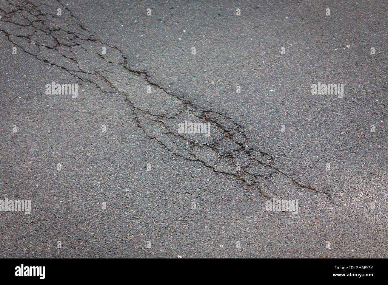 Vehicles pass a pot hole and damaged road surface at Godley cutting ...