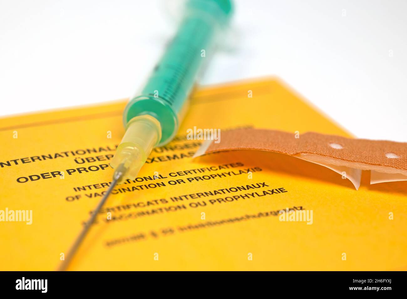International vaccination record with syringe and plaster in a close-up ...