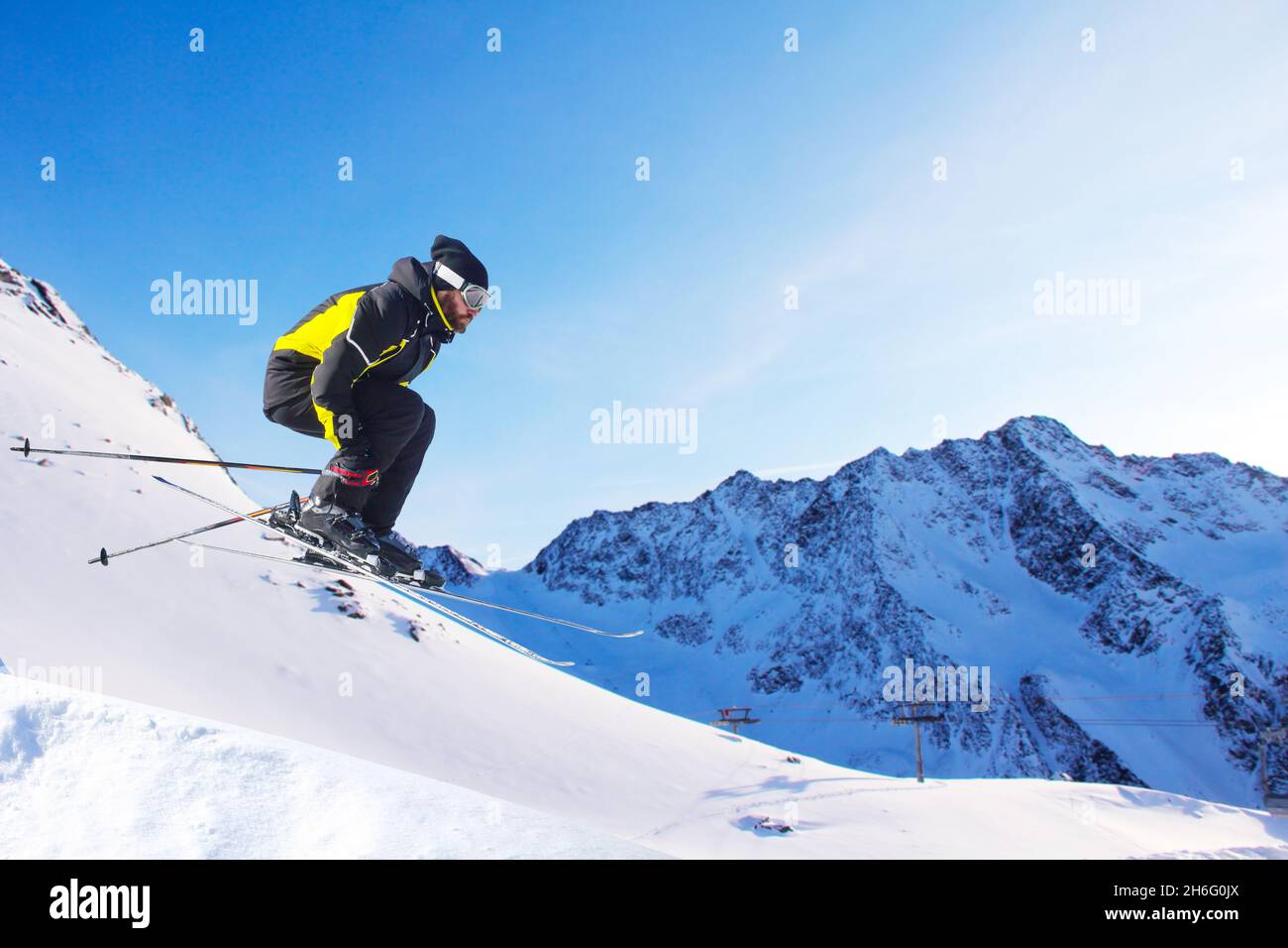 Jumping skier at jump with alpine high mountains Stock Photo - Alamy