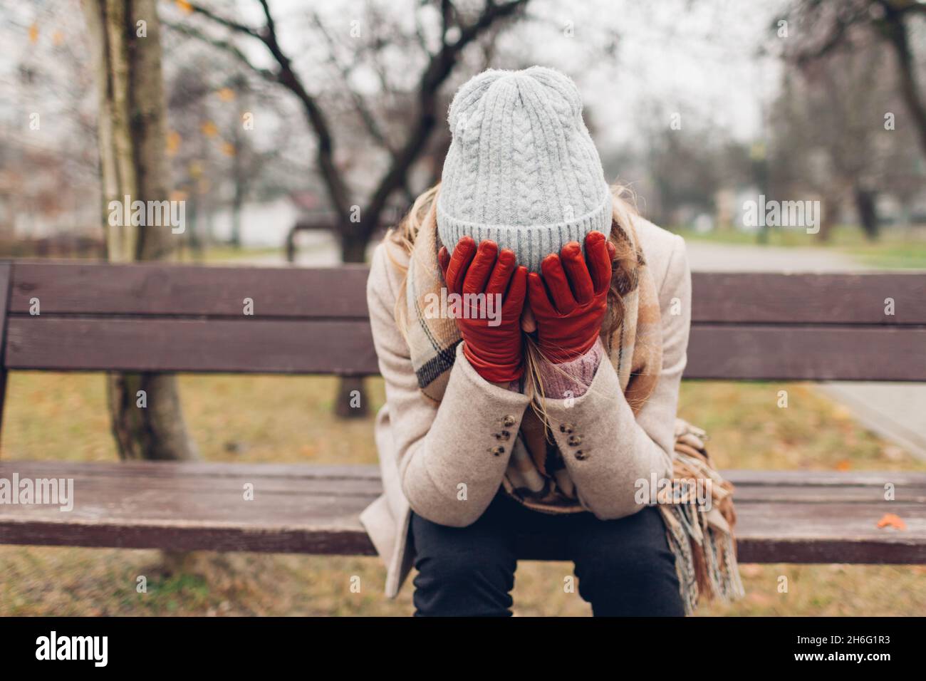 Depression and loneliness. Sad devastated young woman sitting on bench ...