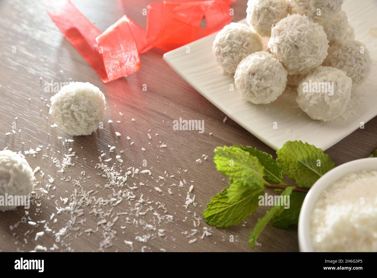 Kitchen table with coconut balls prepared for event with bowl with ...