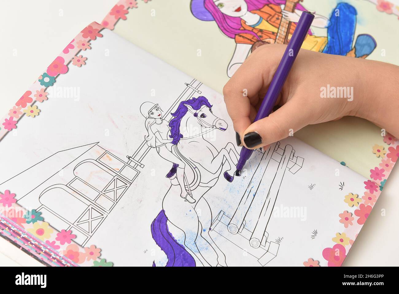 Closeup of a female hand coloring picture with a purple marker Stock ...