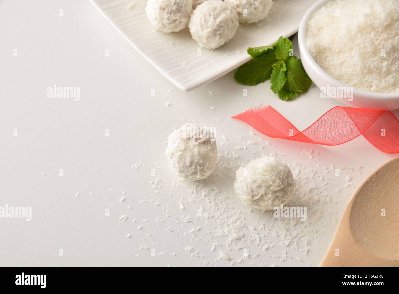 Kitchen table with coconut balls prepared for event with bowl with ...